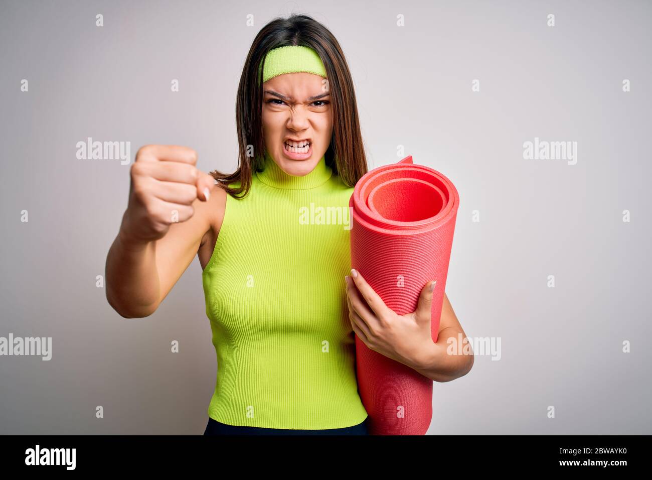 Beautiful sporty girl doing sport wearing sportswear holding yoga mat ...