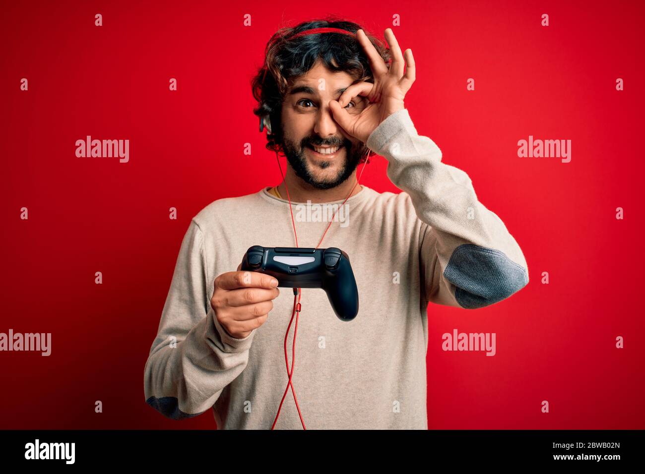 Young gamer man with curly hair and beard playing video game using ...