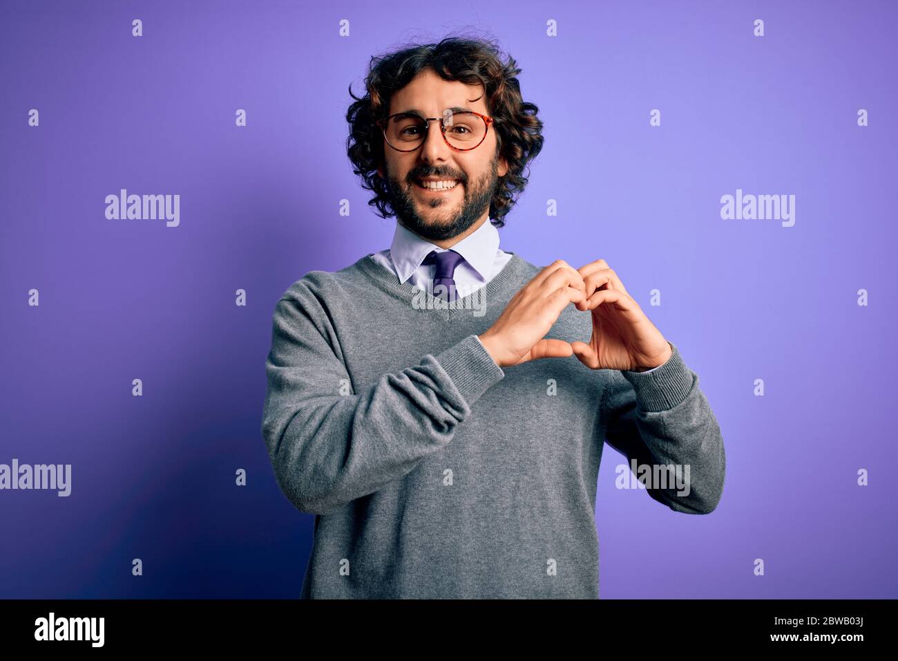 Handsome businessman with beard wearing tie and glasses standing over ...
