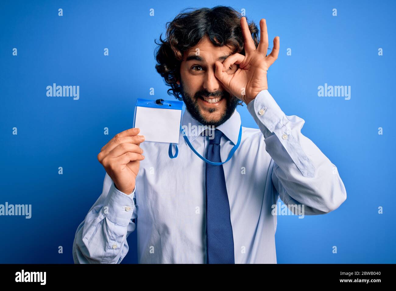 Young handsome business man with beard holding id card identification ...