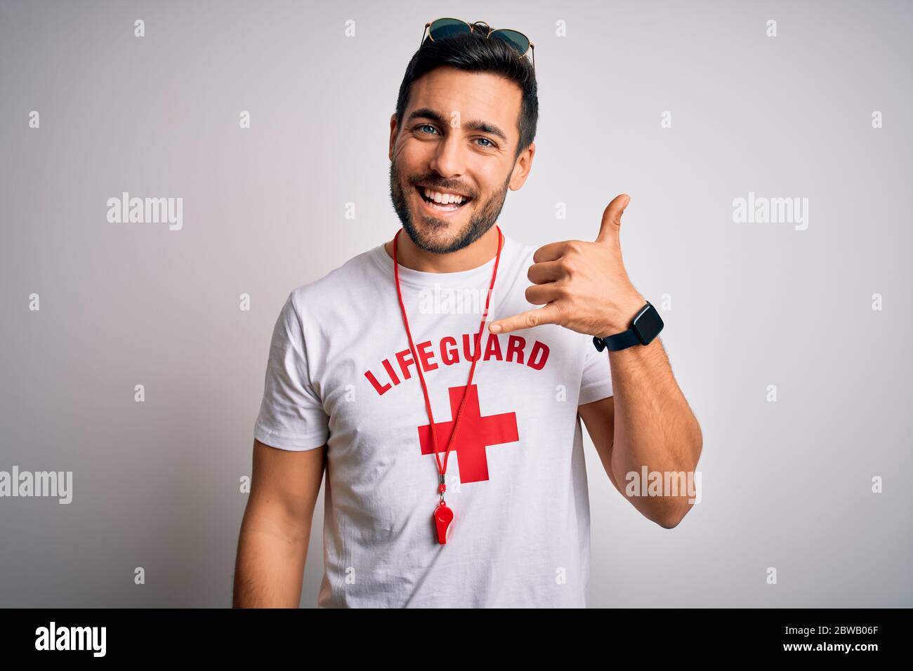 Young handsome lifeguard man with beard wearing t-shirt with red cross ...