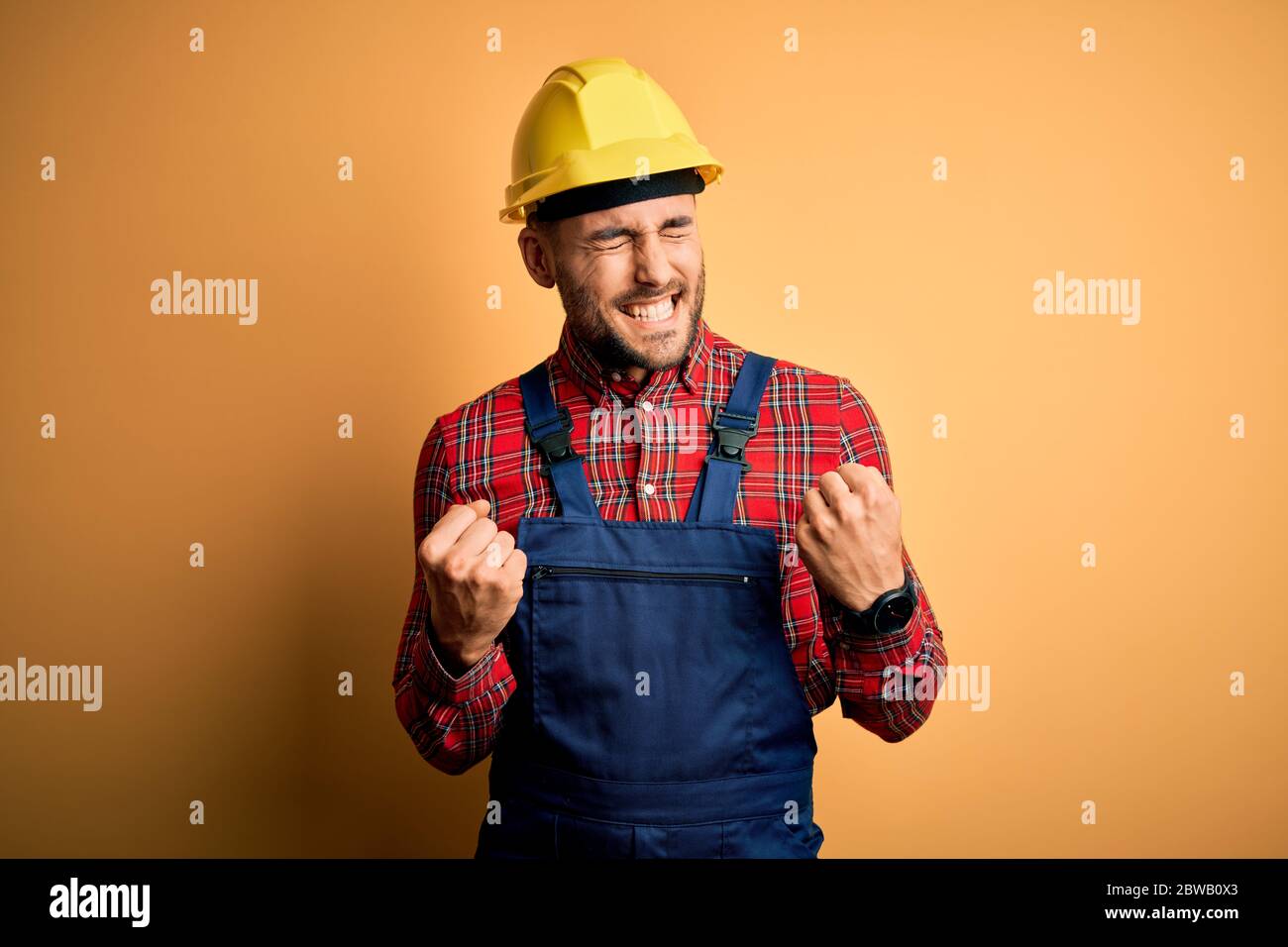 Young builder man wearing construction uniform and safety helmet over ...