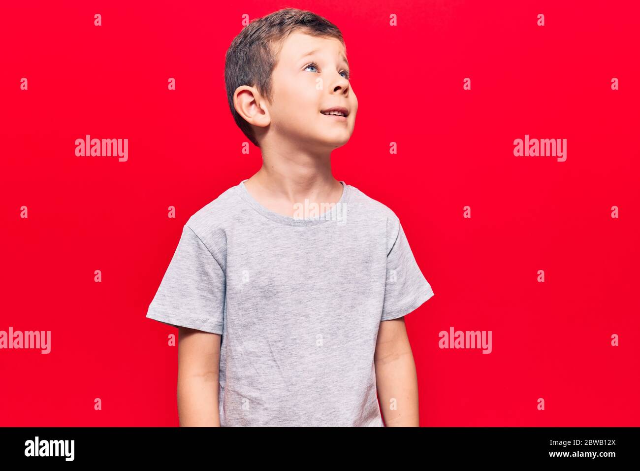 Cute blond kid wearing casual clothes looking away to side with smile ...