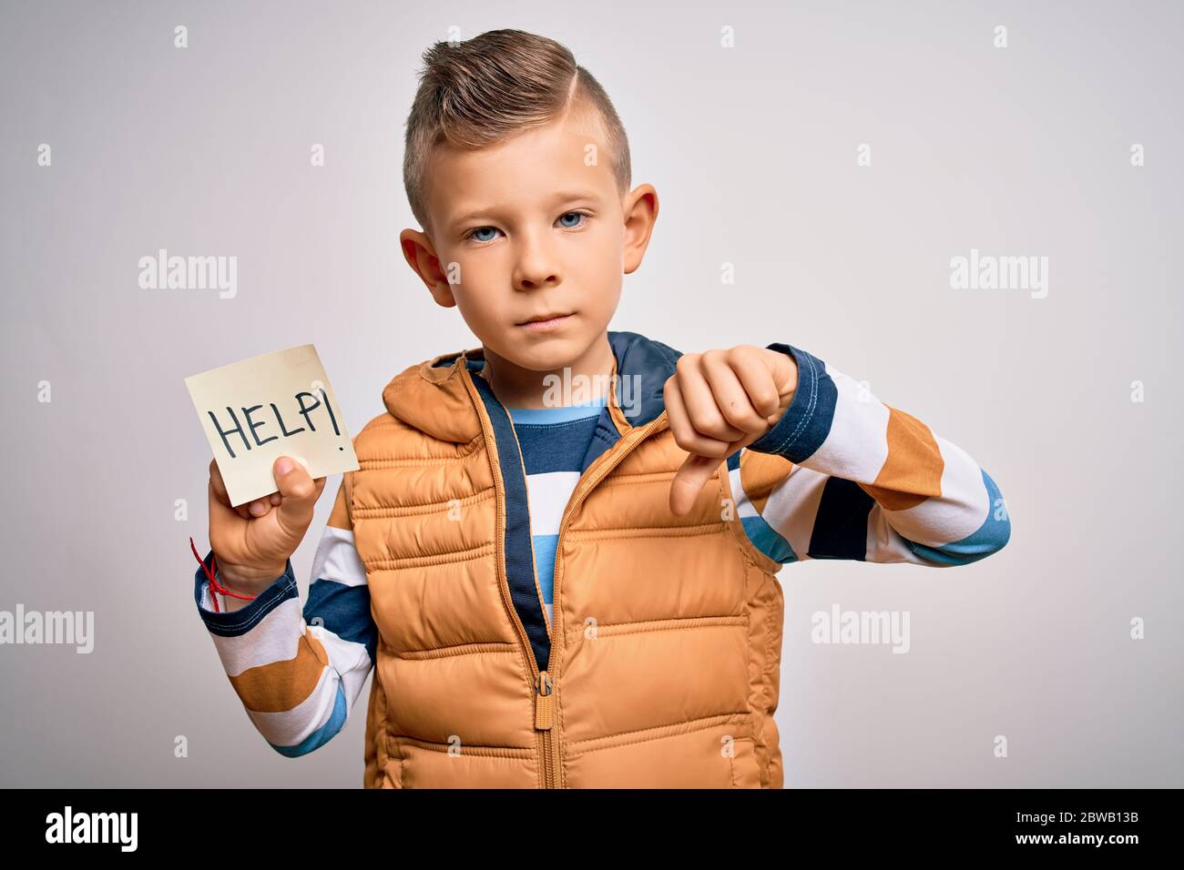 Young little caucasian kid asking for help on a paper note as violence ...