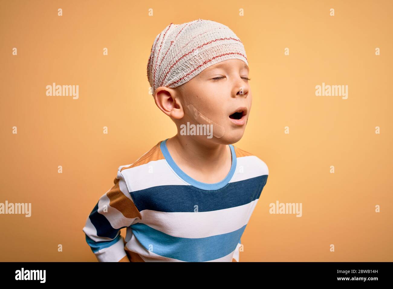 Young little caucasian kid injured wearing medical bandage on head over ...