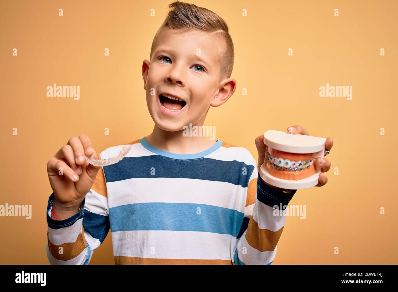 Little kid boy holding professional orthodontic denture with metal ...