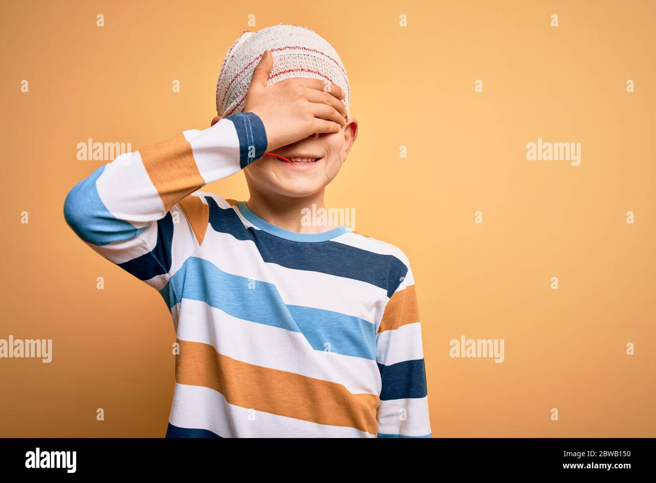 Young little caucasian kid injured wearing medical bandage on head over ...
