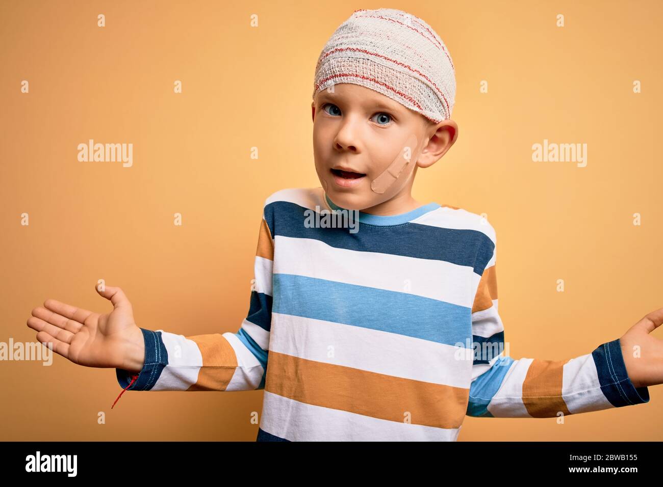 Young little caucasian kid injured wearing medical bandage on head over ...