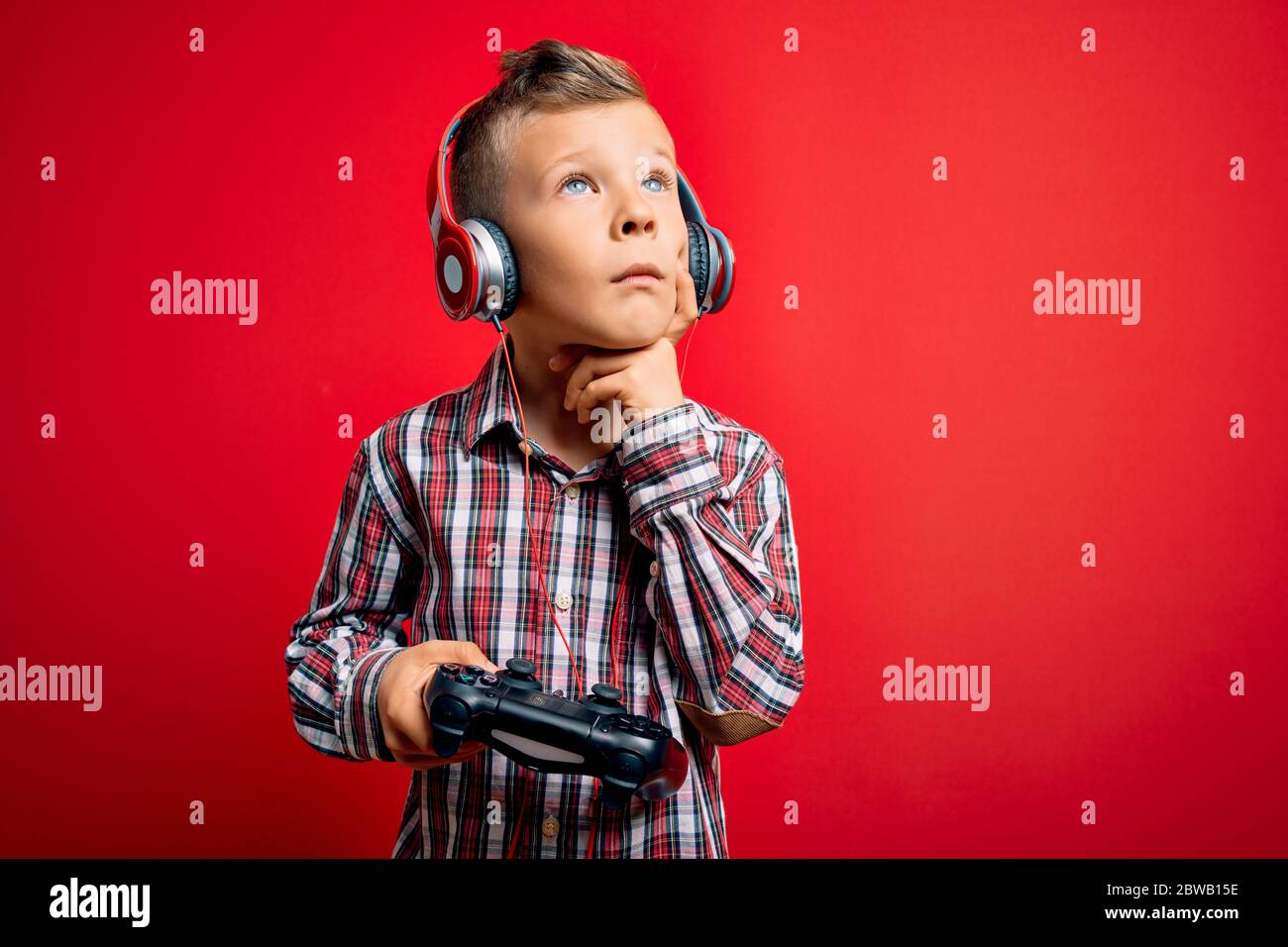 Young little caucasian gamer kid playing video games using gamepad ...