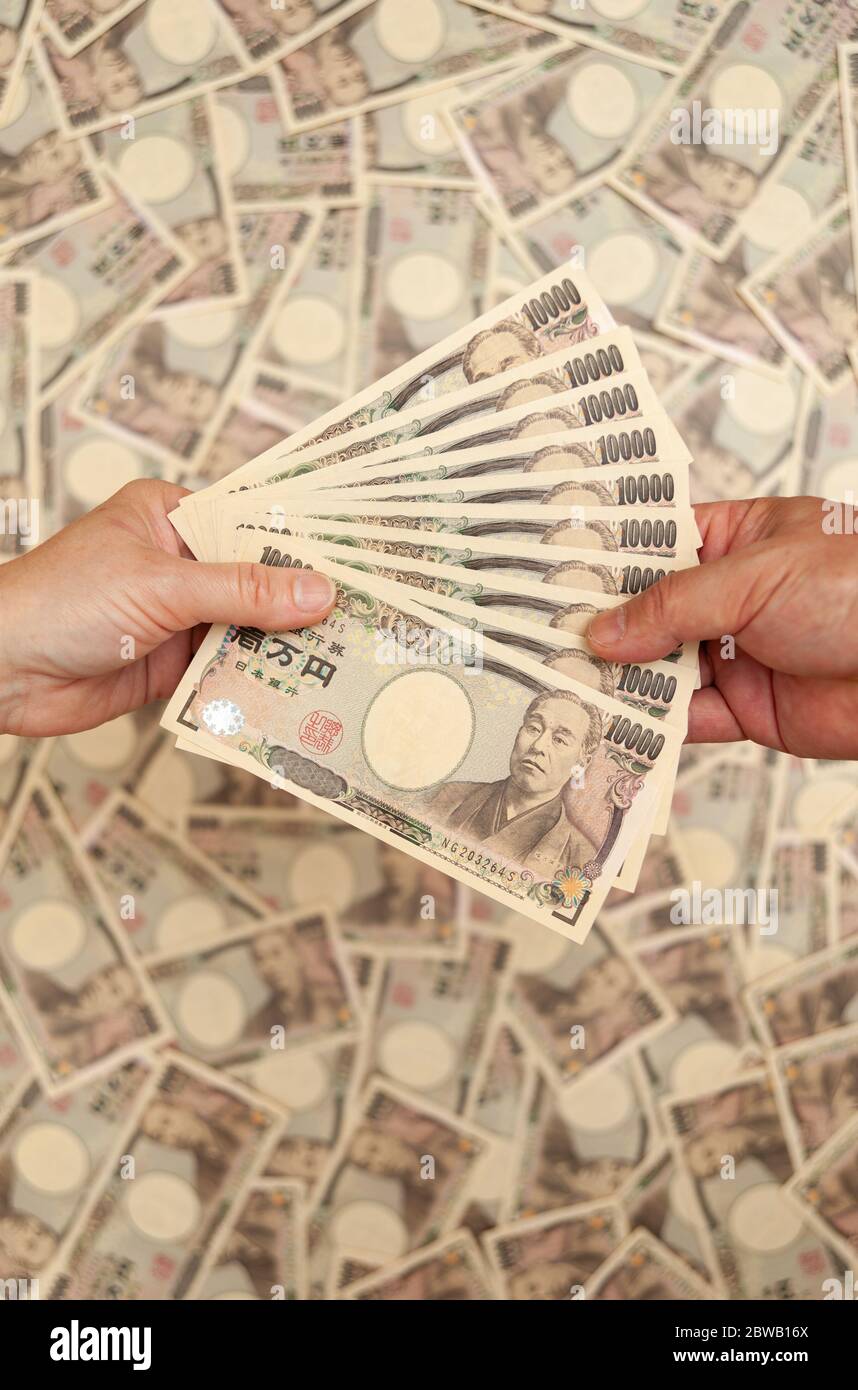 YEN - Japanese money: Hands holding (paying / receiving) 100,000 yen ...