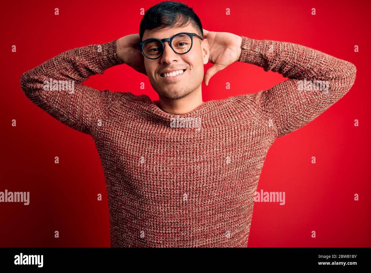 Young handsome hispanic man wearing nerd glasses over red background ...