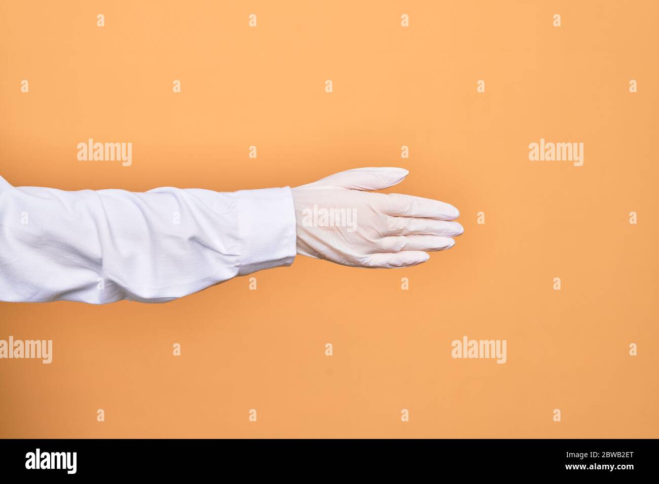 Hand of a person wearing medical surgical glove doing handshake sign ...
