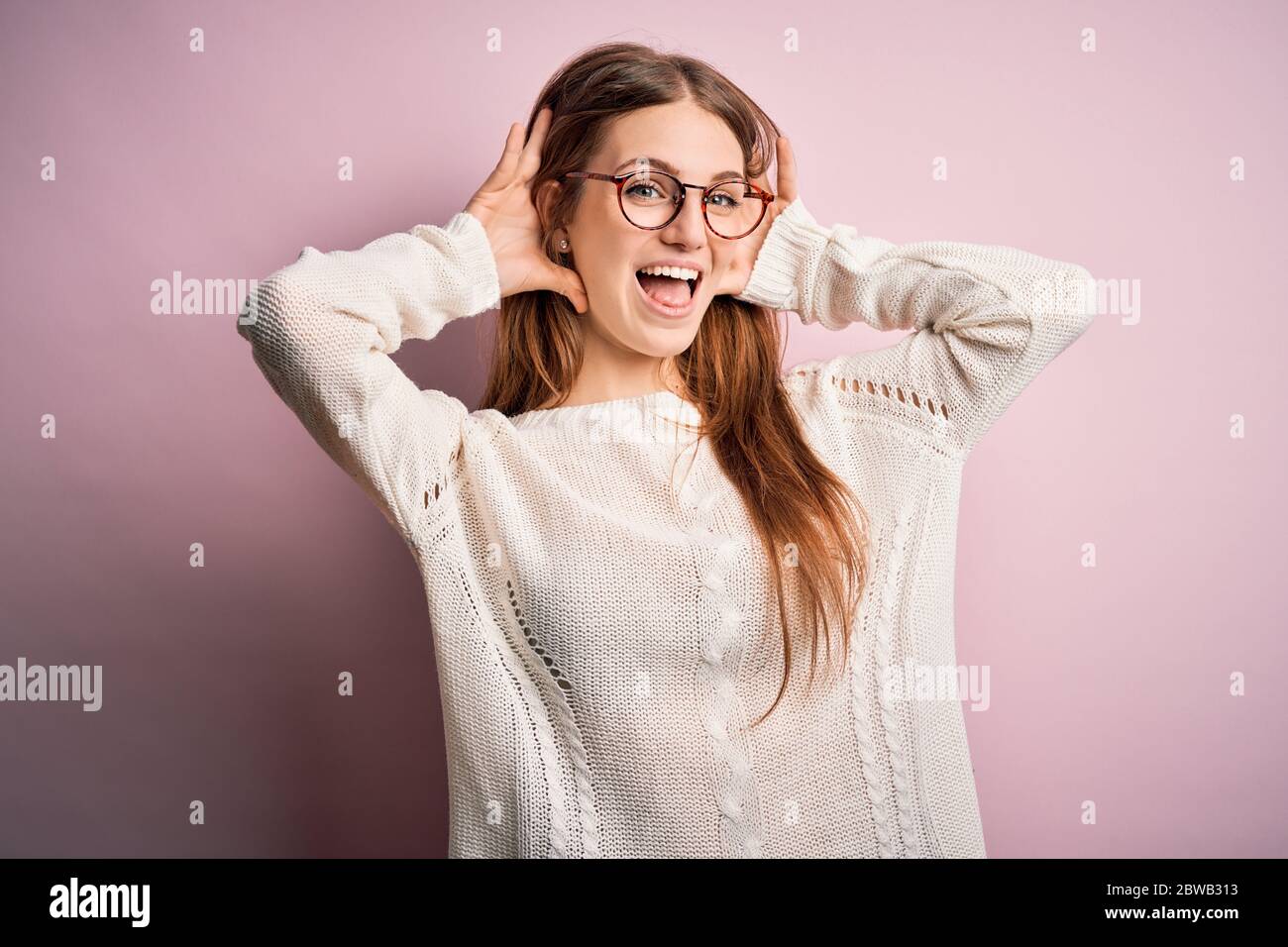 Young beautiful redhead woman wearing casual sweater and glasses over ...