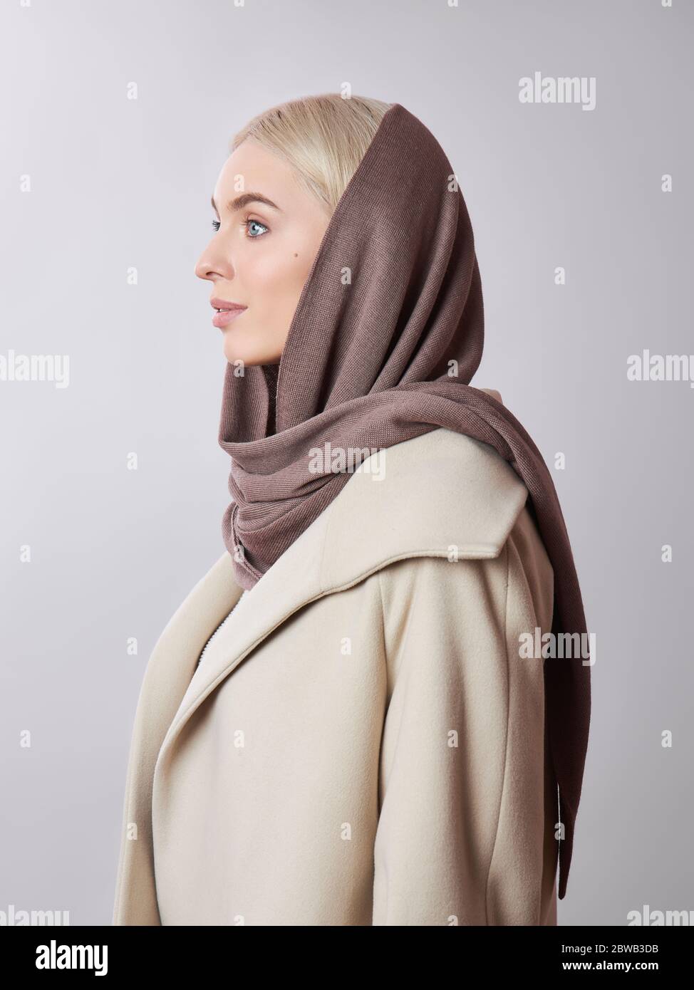 European Muslim woman with a blonde hair in a headscarf shawl dressed ...