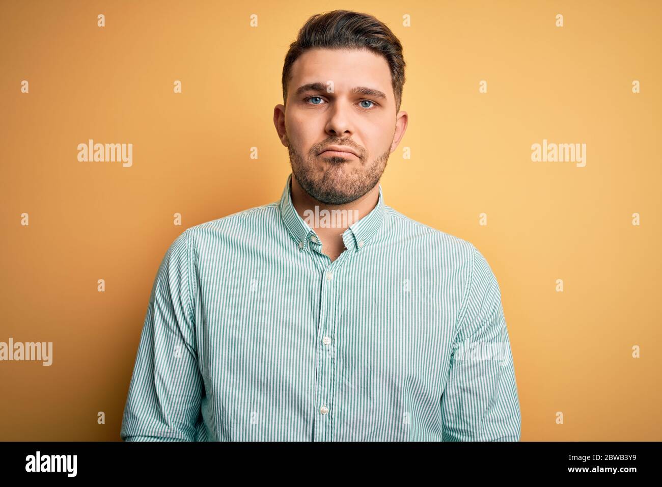 Young business man with blue eyes wearing elegant green shirt over ...