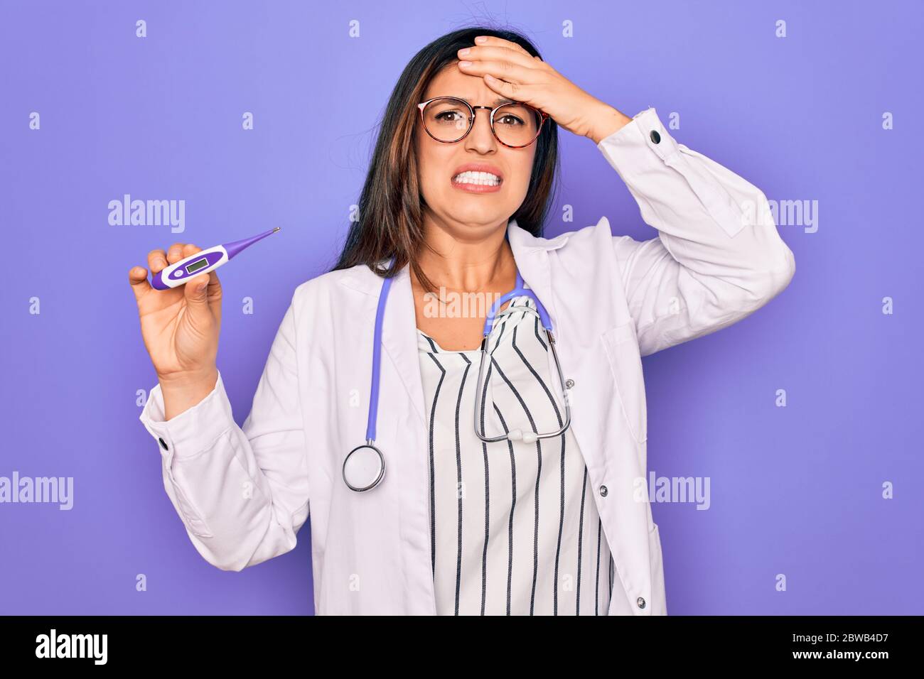 Professional doctor woman showing medical thermometer over purple ...