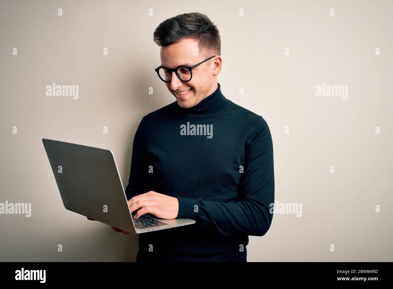 Young handsome caucasian business man wearing glasses using computer ...
