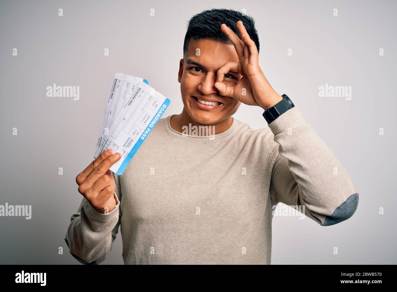 Young handsome latin tourist man on vacation holding airline boarding ...