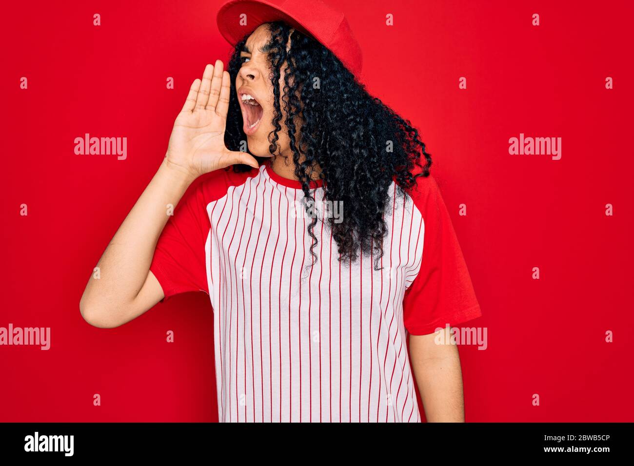 Young african american curly sportswoman wearing baseball cap and ...
