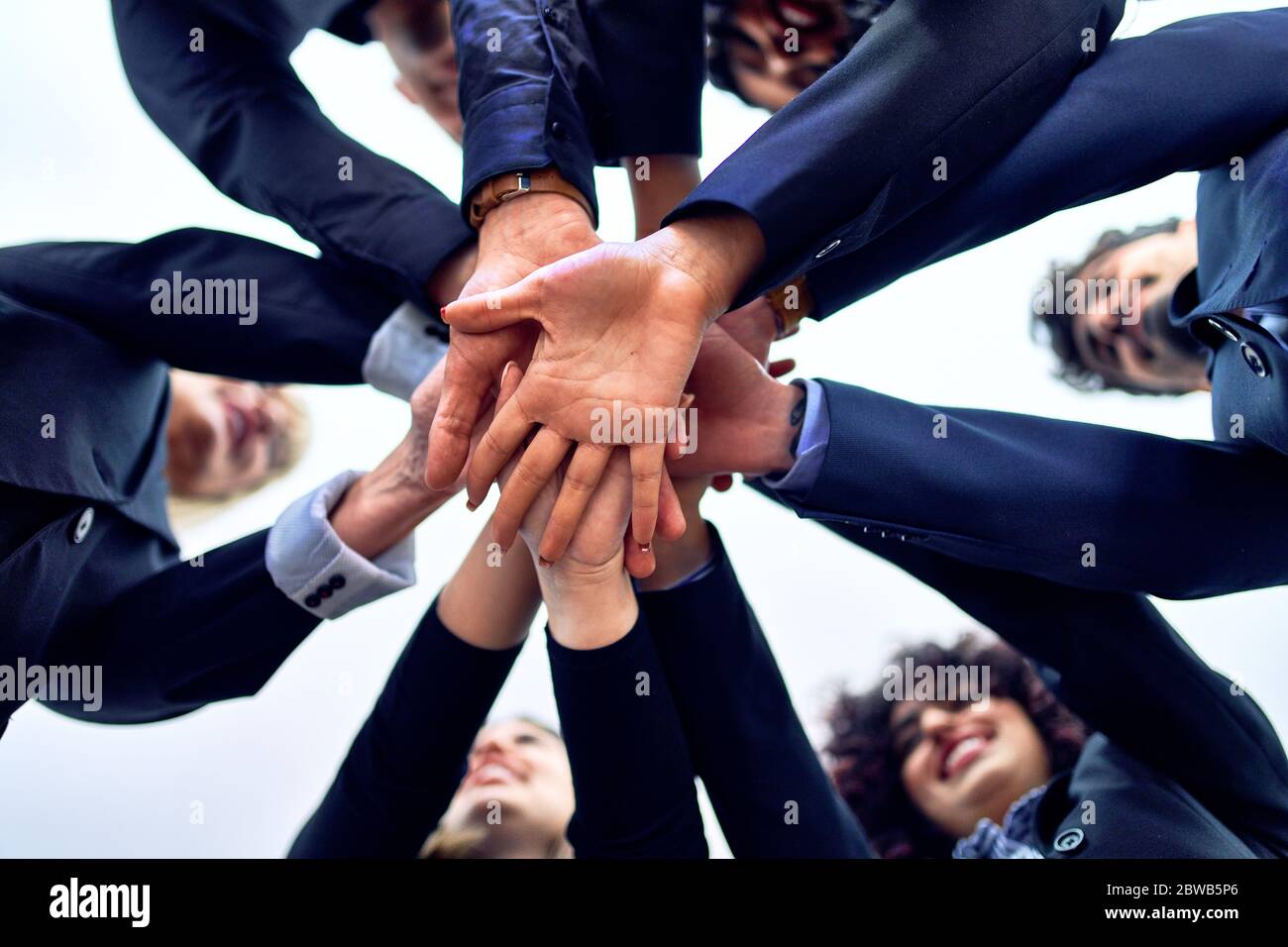 Group of business workers standing with hands together at the office ...