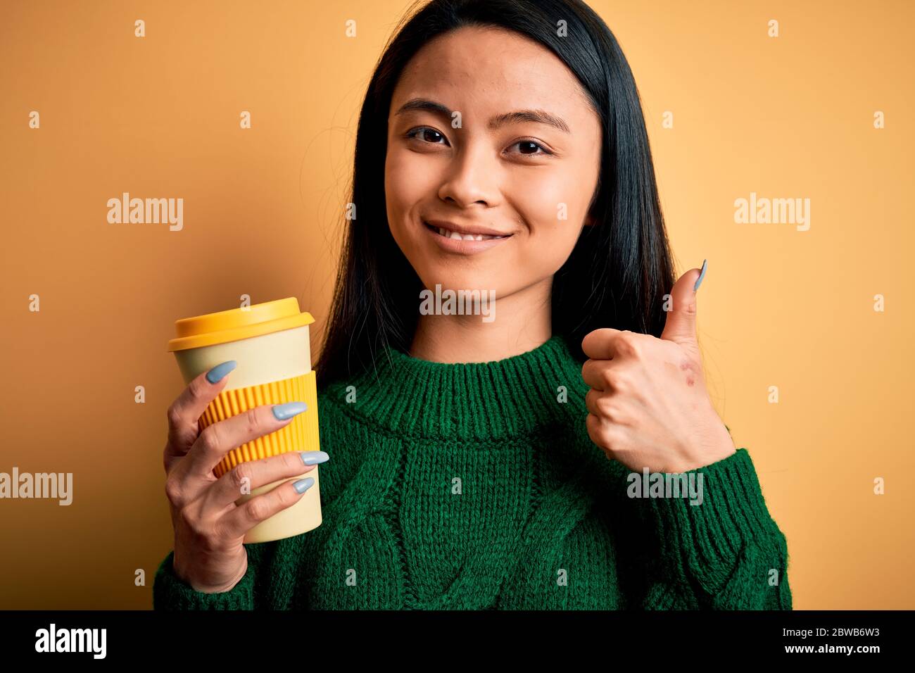 Young beautiful chinese woman drinking cup of coffee over isolated ...