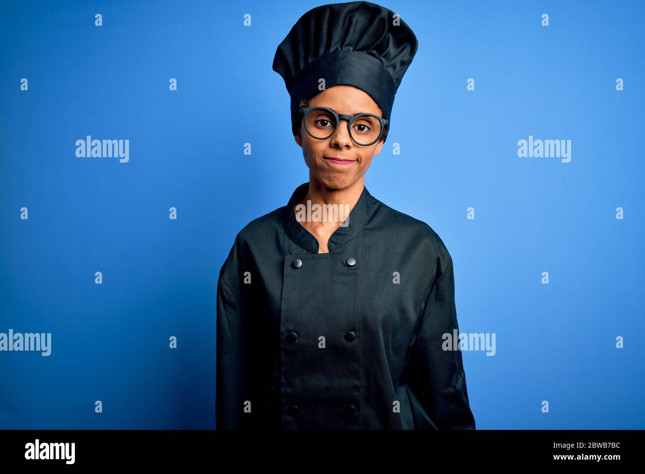 Young african american chef woman wearing cooker uniform and hat over ...