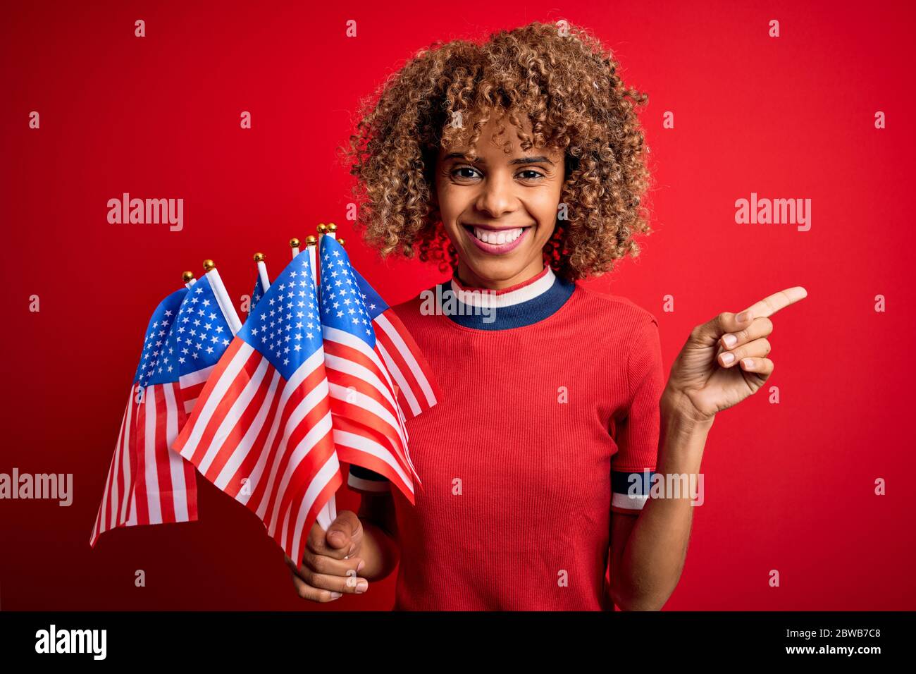 Young african american patriotic curly woman holding united states ...