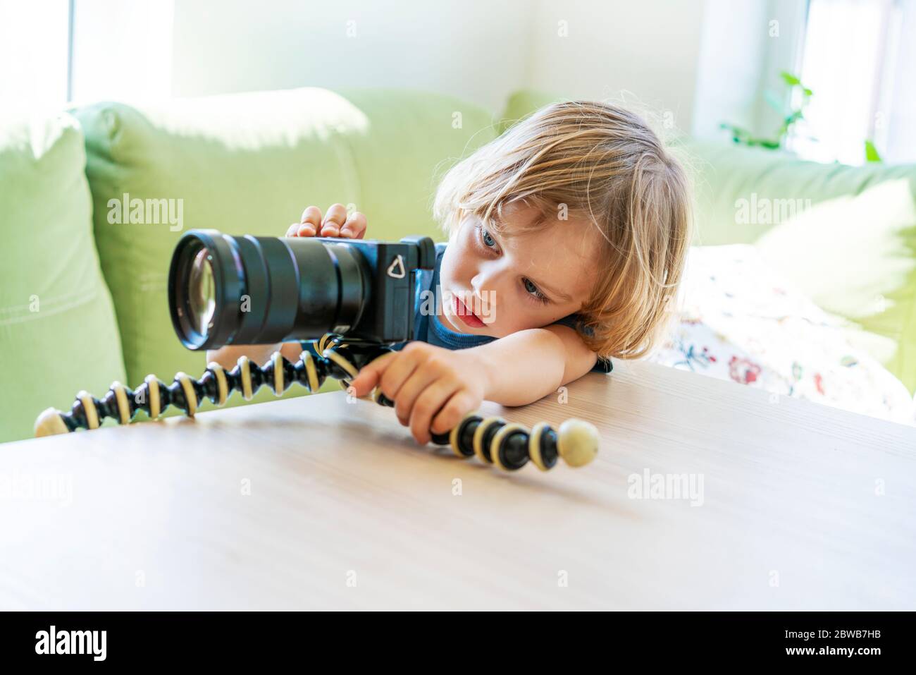 Cute funny little boy practicing in taking photo or video shooting with ...