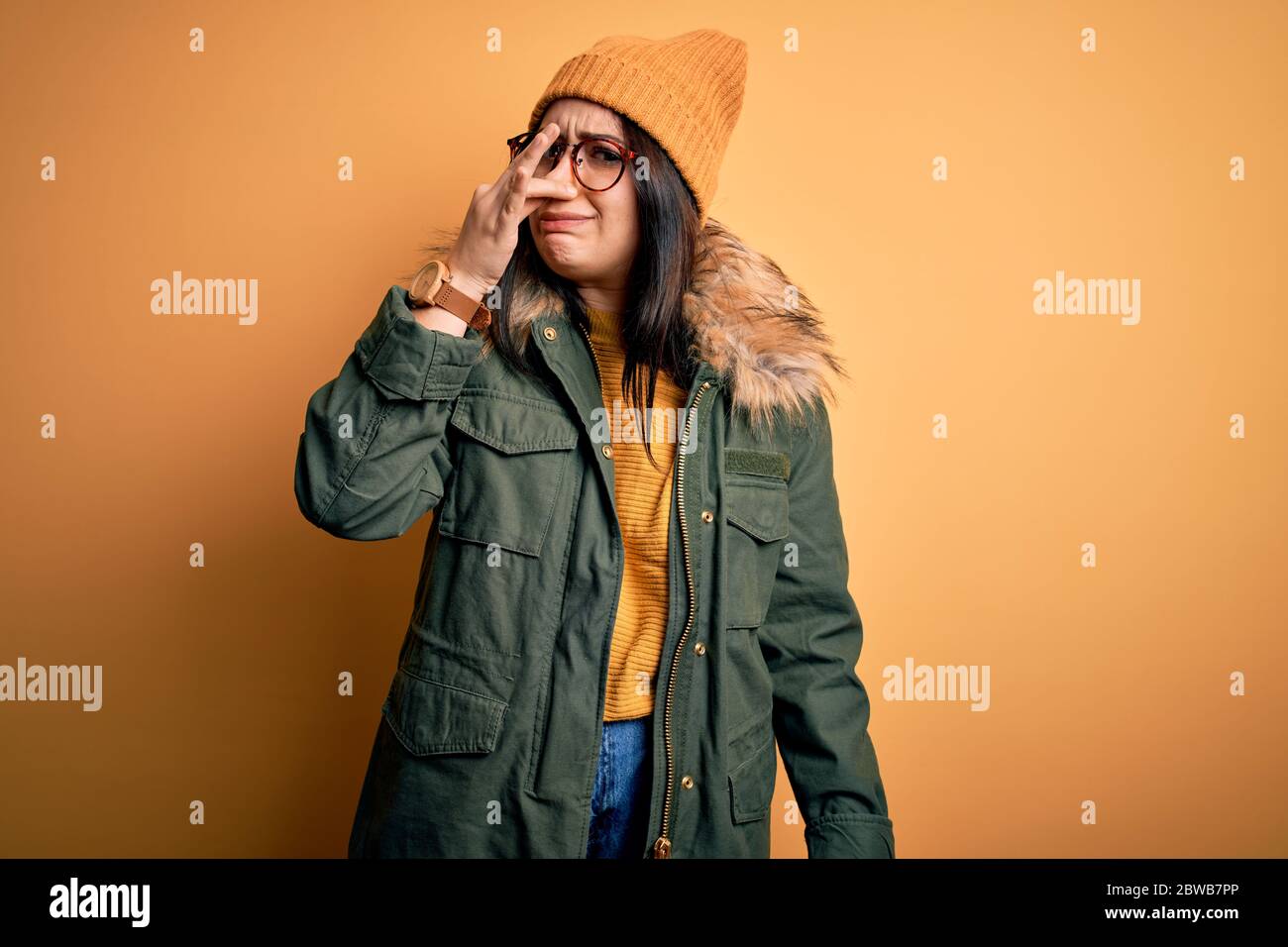 Young Brunette Woman Wearing Glasses And Winter Coat With Hat Over