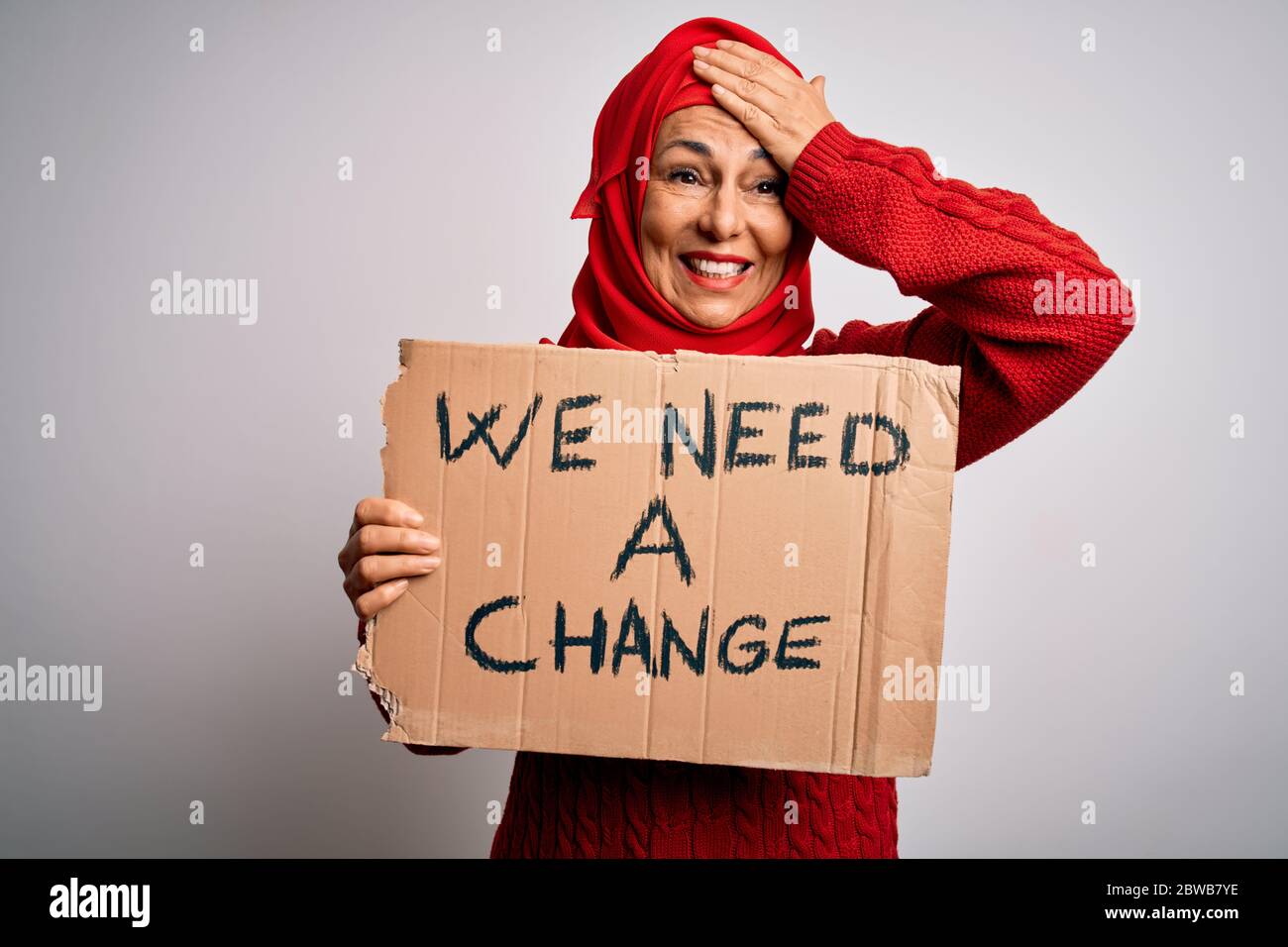 Middle age woman wearing muslim hijab asking for change holding banner ...