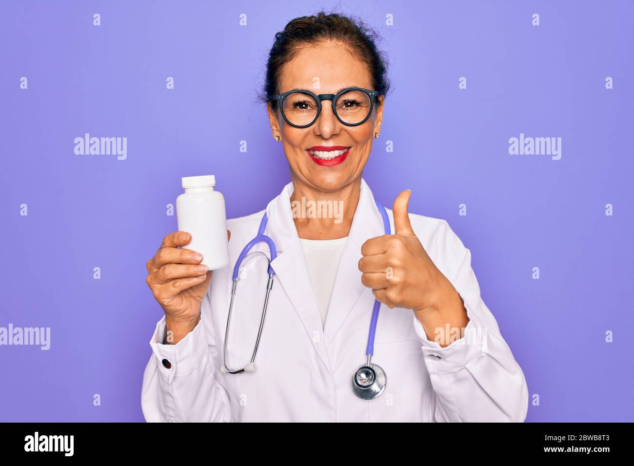 Middle age senior professional doctor woman holding pharmaceutical ...