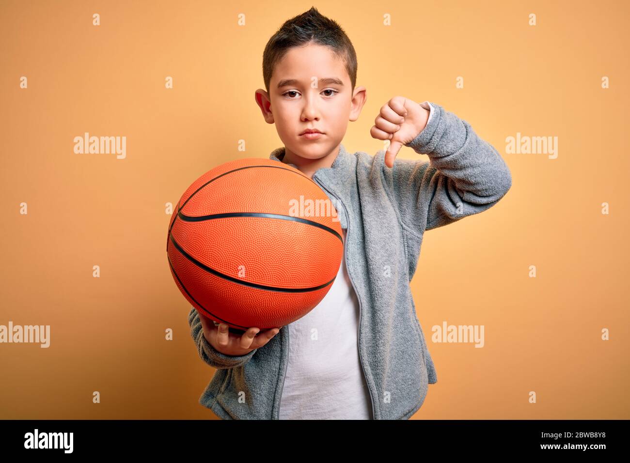 Young little boy kid playing with basketball game ball over isolated ...