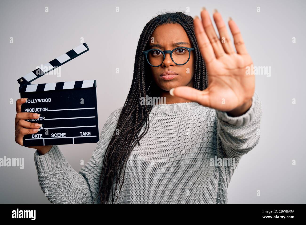 Young african american director girl filming a movie using clapboard ...