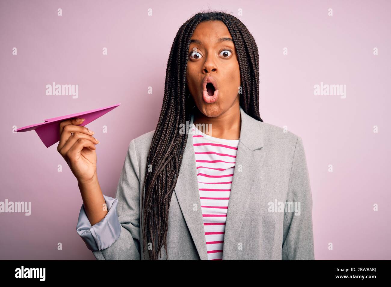 Young african american business woman holding paper plane as ...