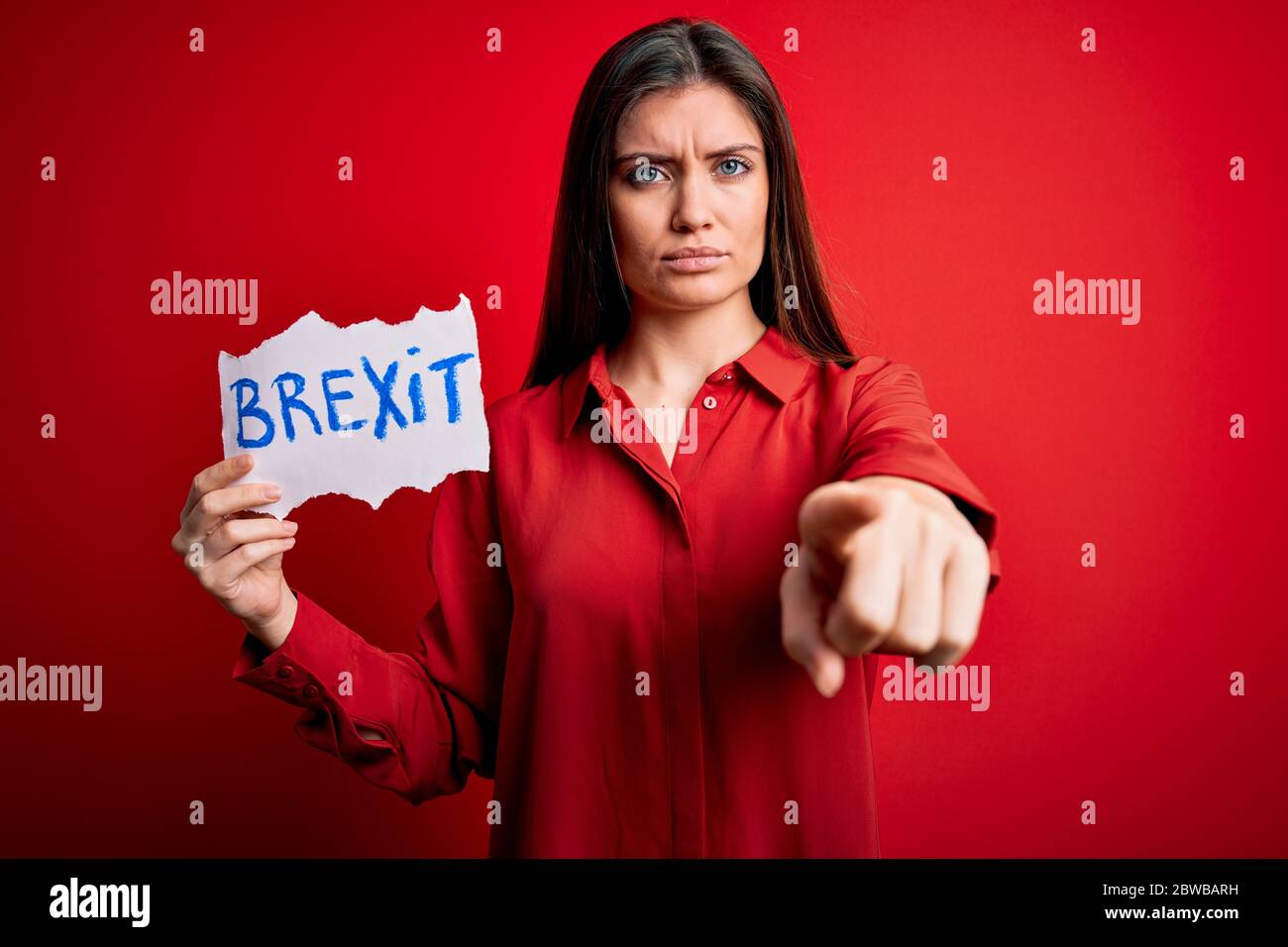 Young beautiful woman with blue eyes holding paper with brexit message ...
