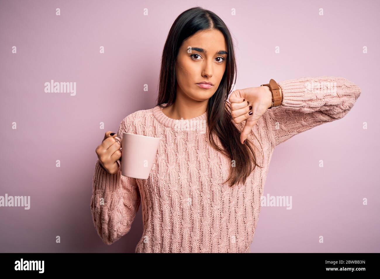 Young beautiful brunette woman drinking cup of coffee over isolated ...