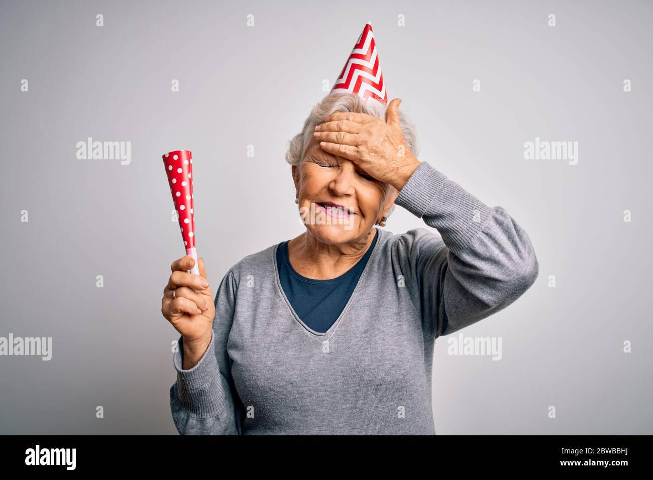 Senior beautiful grey-haired woman celebrating birthday wearing funny ...