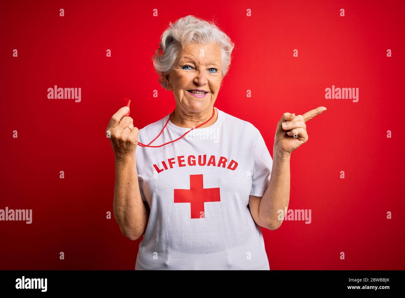 Senior beautiful grey-haired lifeguard woman wearing t-shirt with red ...