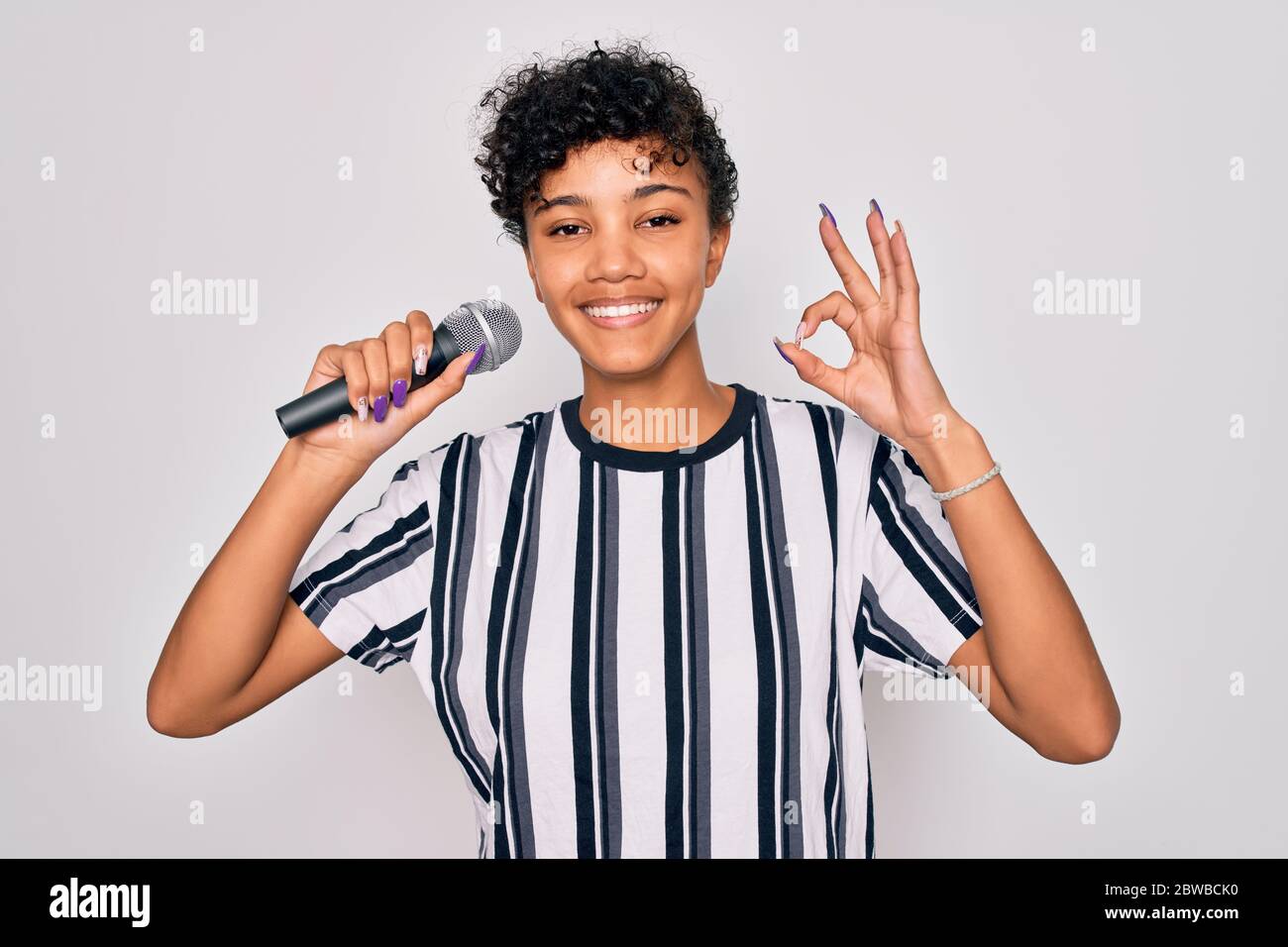 Beautiful african american afro singer woman singing using microphone ...