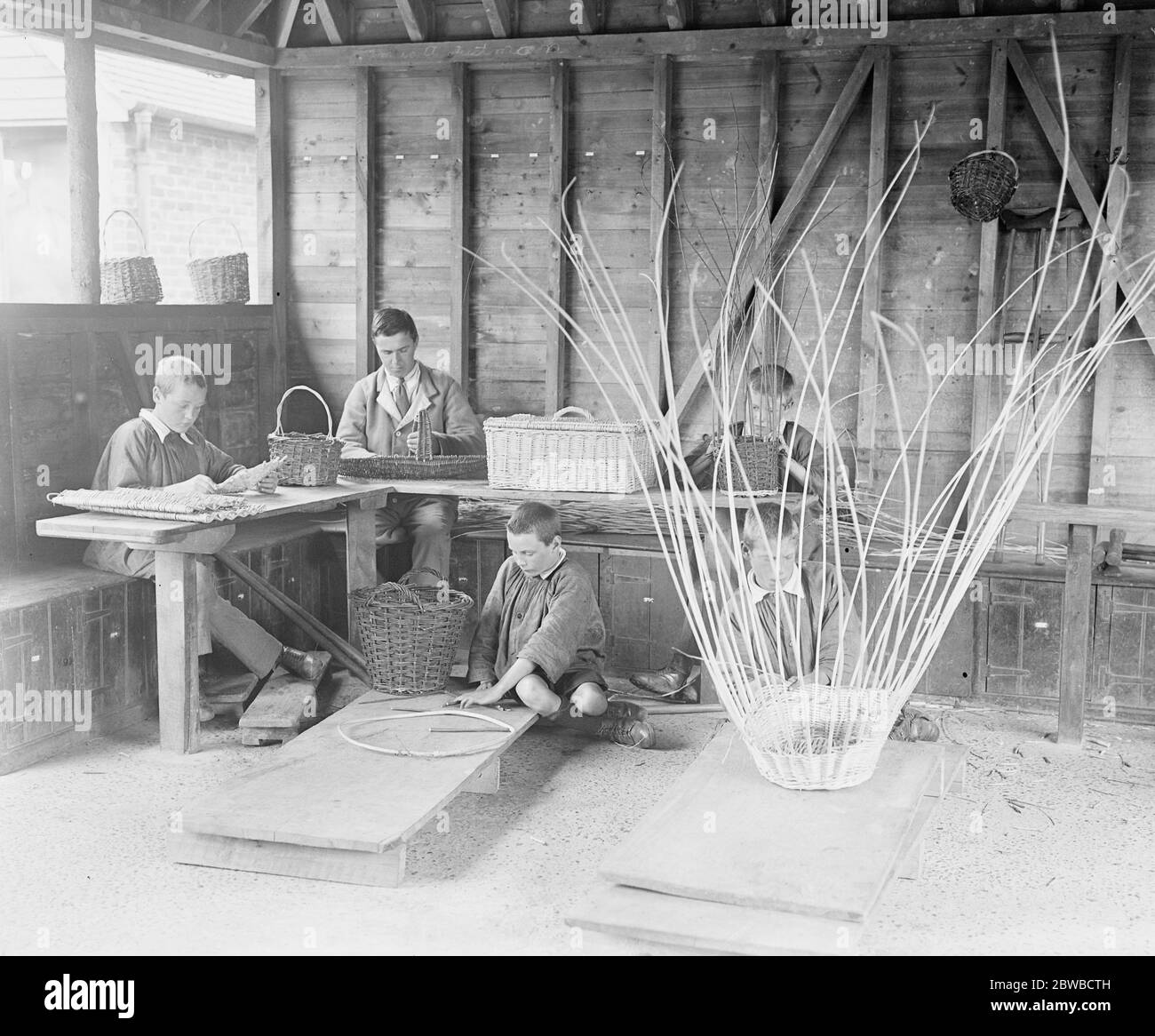 A disabled soldier and children basket weaving at the Princess Louise ...