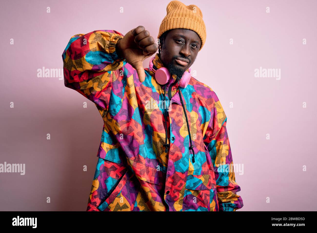 Young handsome african american man wearing colorful coat and cap over ...