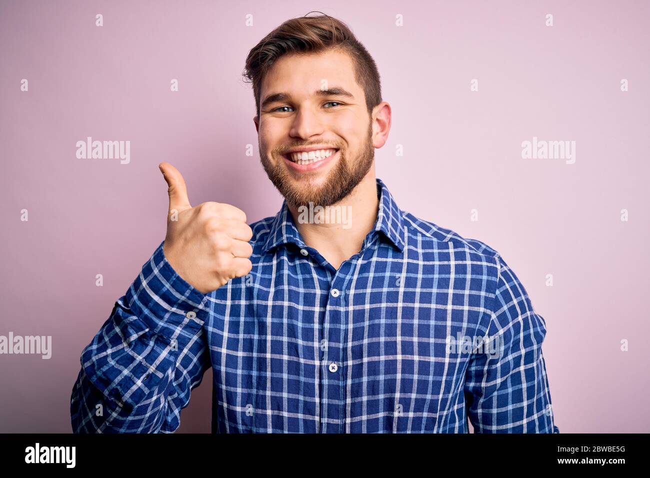 Young handsome blond man with beard and blue eyes wearing casual shirt ...