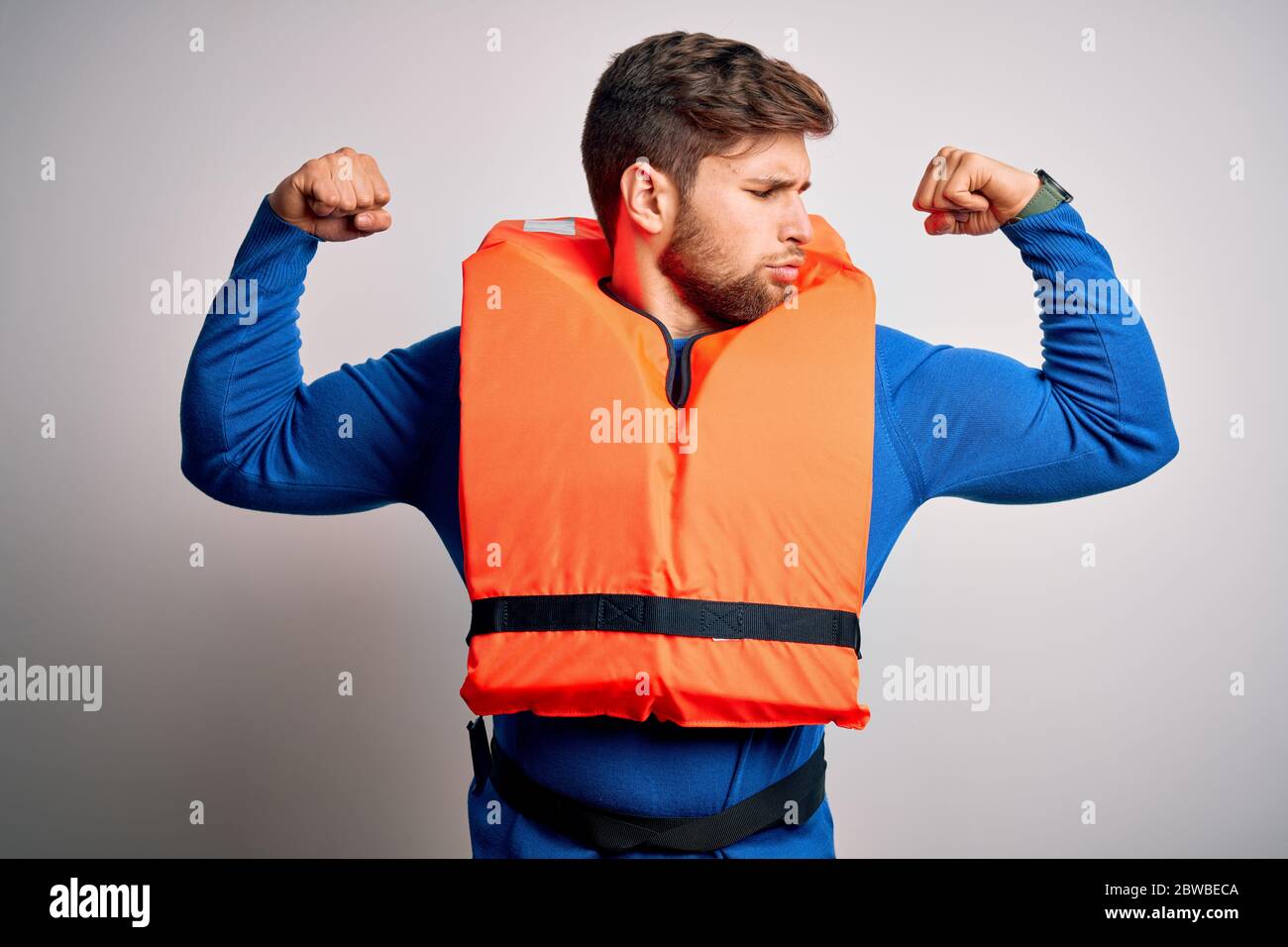 Young blond tourist man with beard and blue eyes wearing lifejacket ...