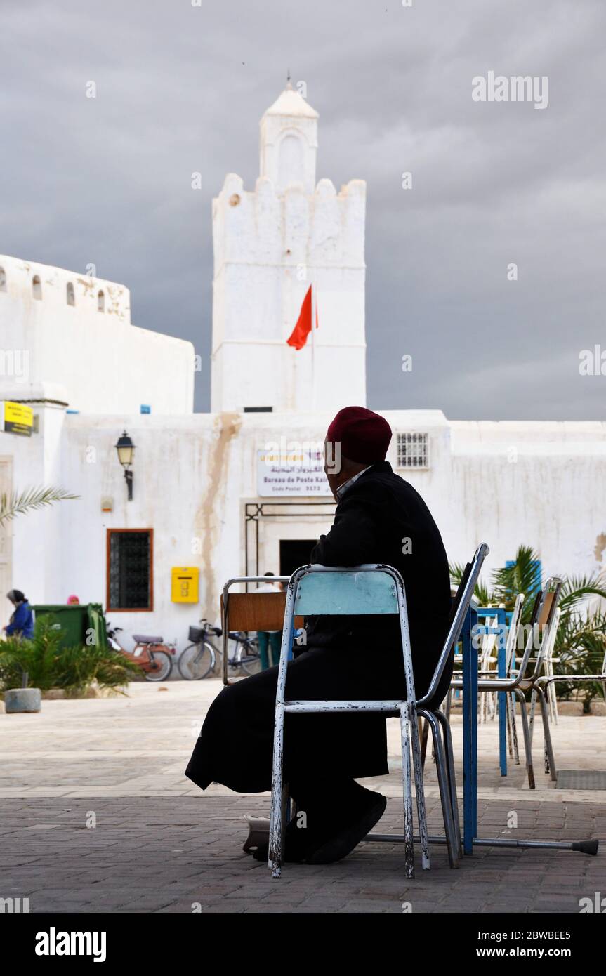 Small square in Kairouan, Tunisia, showing a local man sitting in a ...