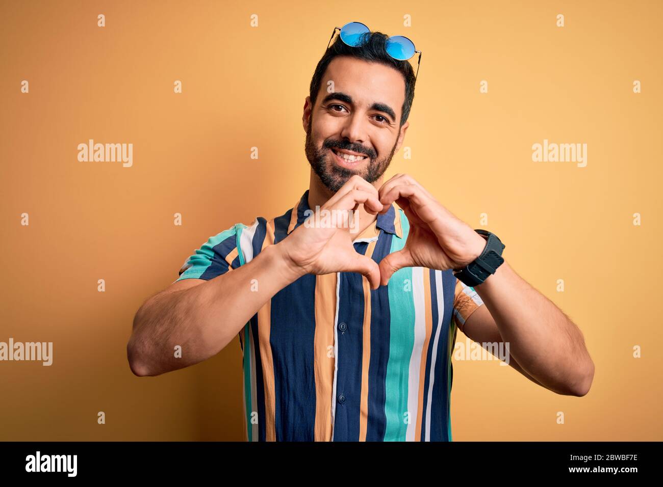 Handsome tourist man with beard on vacation wearing summer striped ...