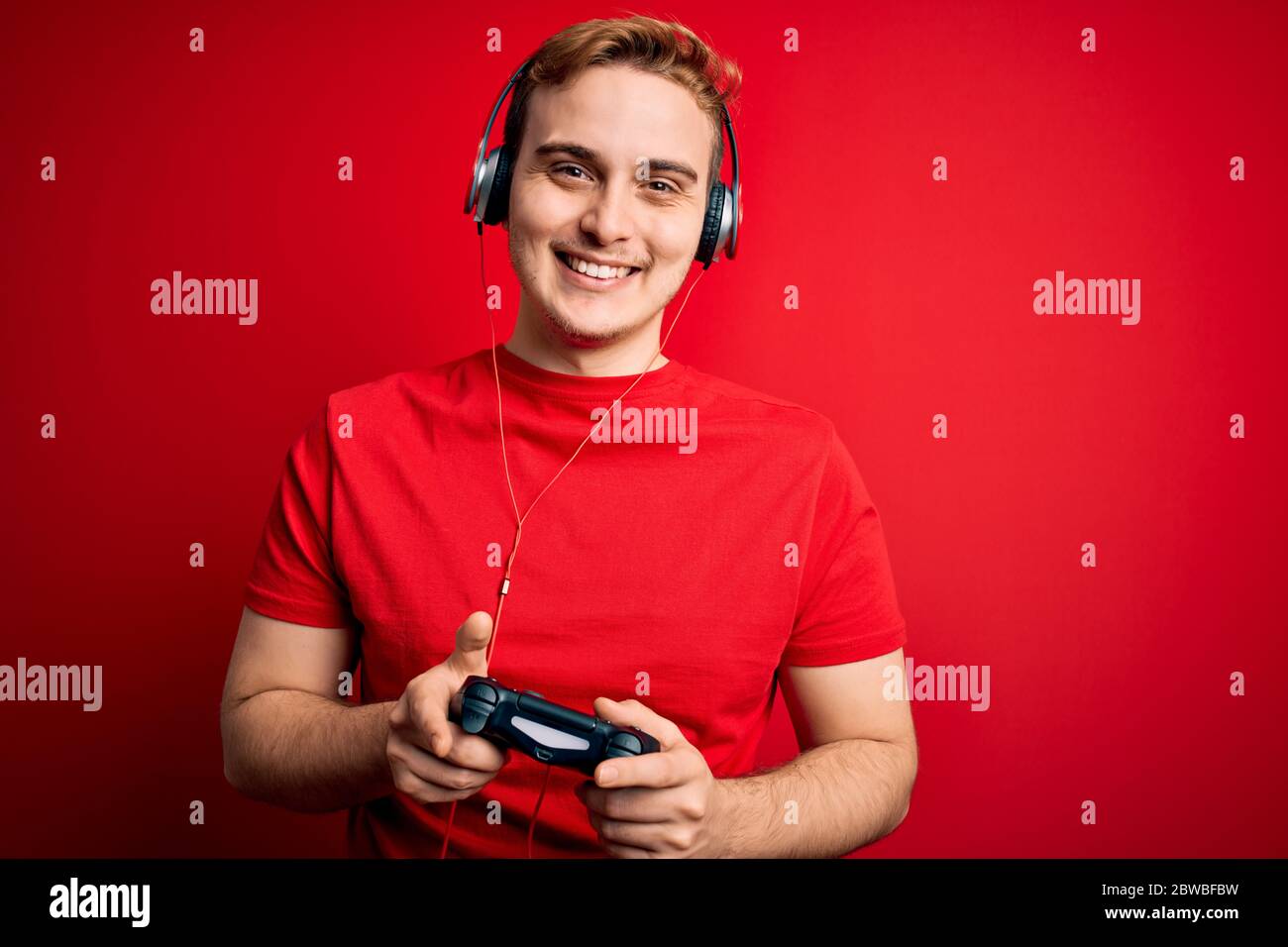Young handsome redhead gamer man playing video game using headphones ...