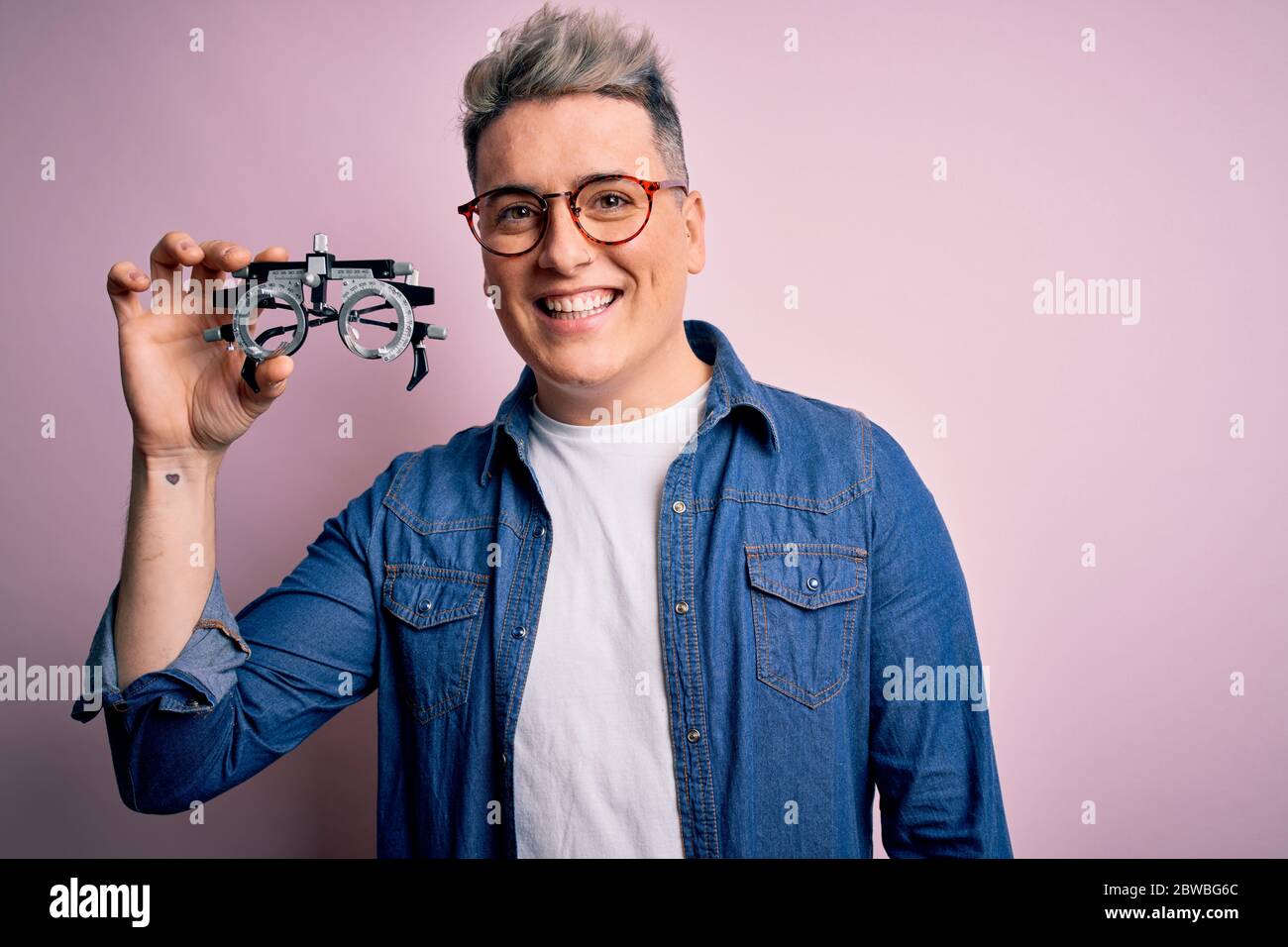 Young modern optical optomestrist man holding optometrical glasses over ...