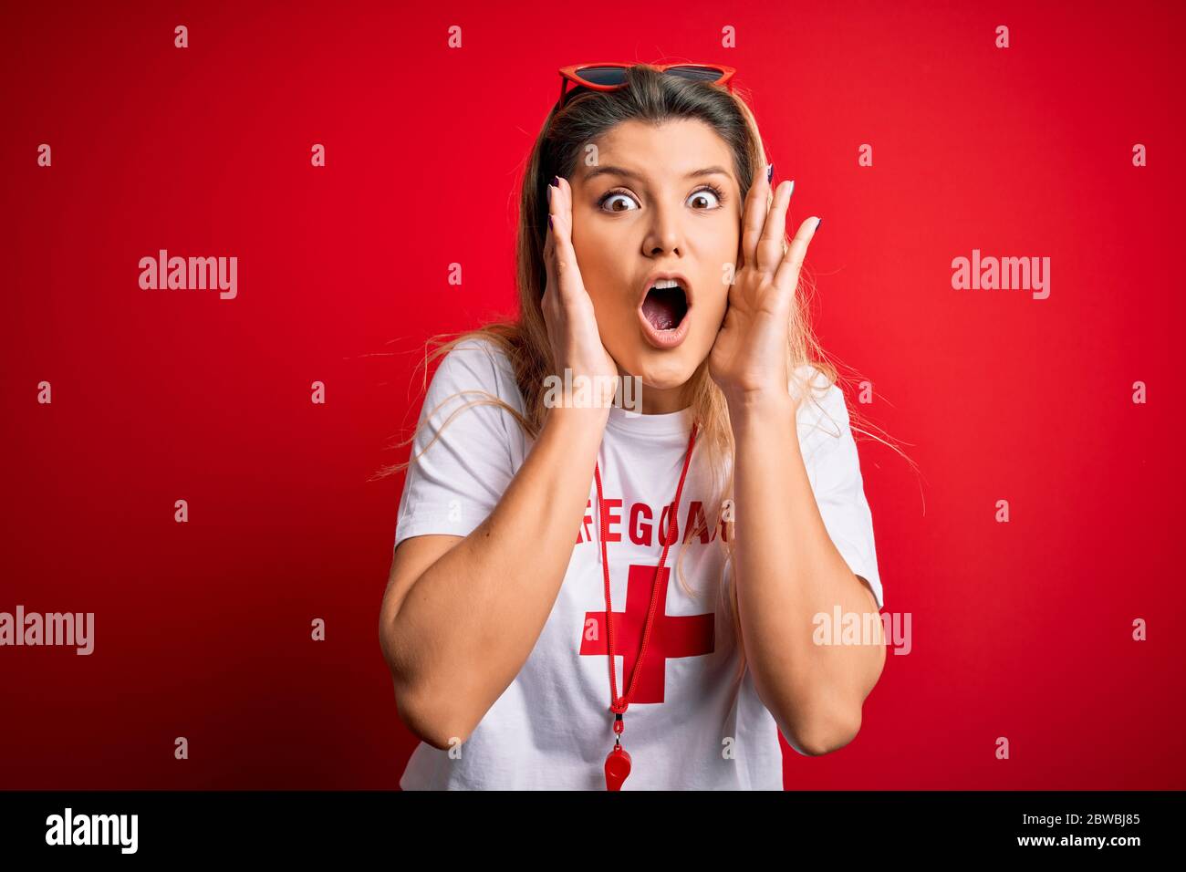 Young beautiful blonde lifeguard woman wearing t-shirt with red cross ...