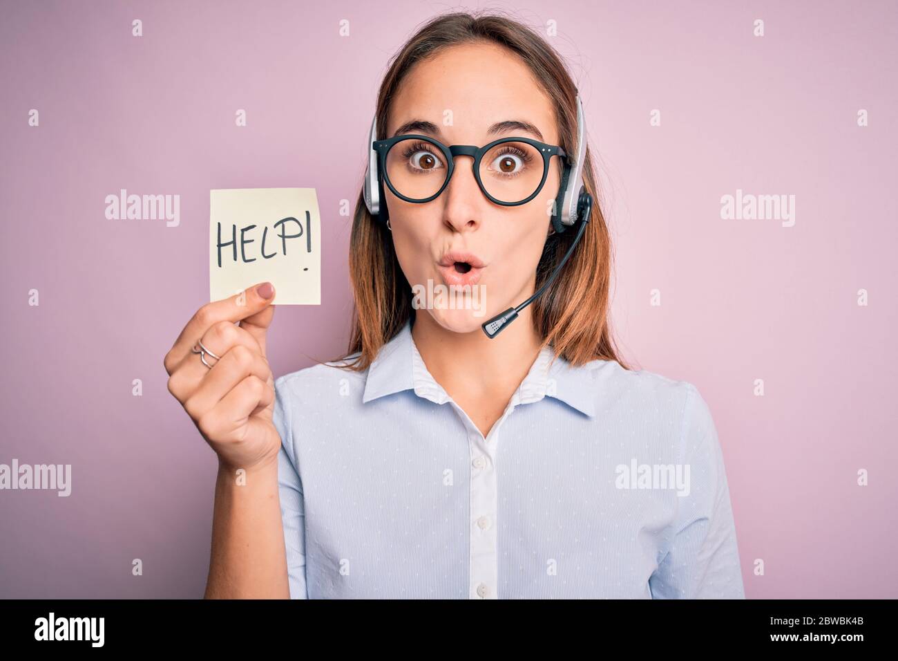 Beautiful call center agent woman working using headset holding help ...