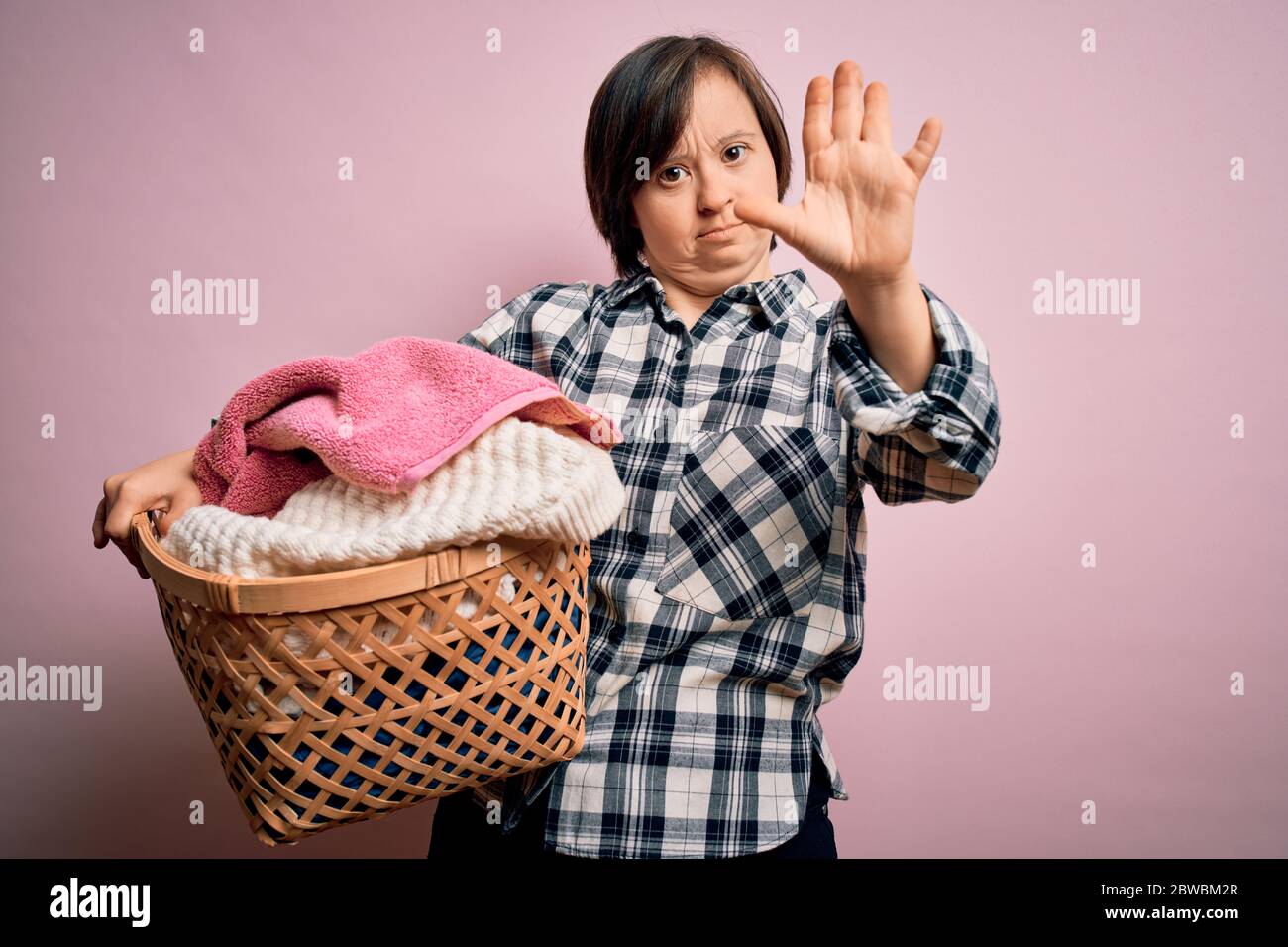 Young down syndrome woman doing housework domestic chores holding ...